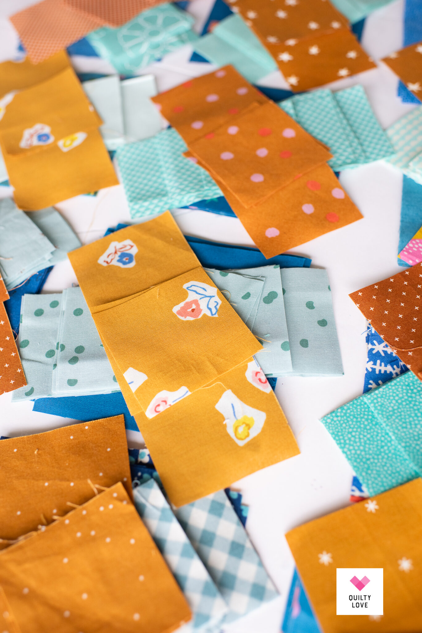 Scrappy Glowing quilt with scrappy low volume background - Quilty Love